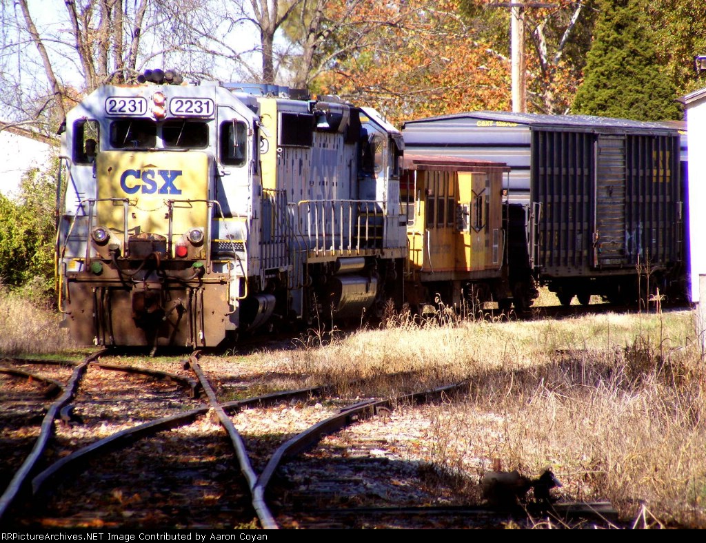 CSX 2231 and 6422 push their caboose and 8 boxcars uphill on the warehouse trackage